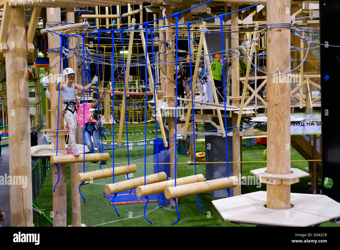 Children age 6-12 attend indoor adventure climbing park Stock Photo - Alamy