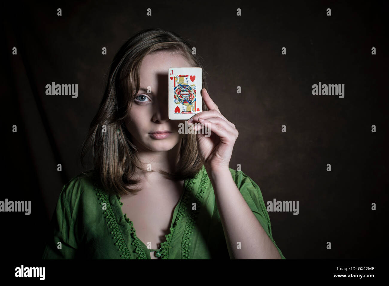 Woman hiding face with playing cards Stock Photo - Alamy