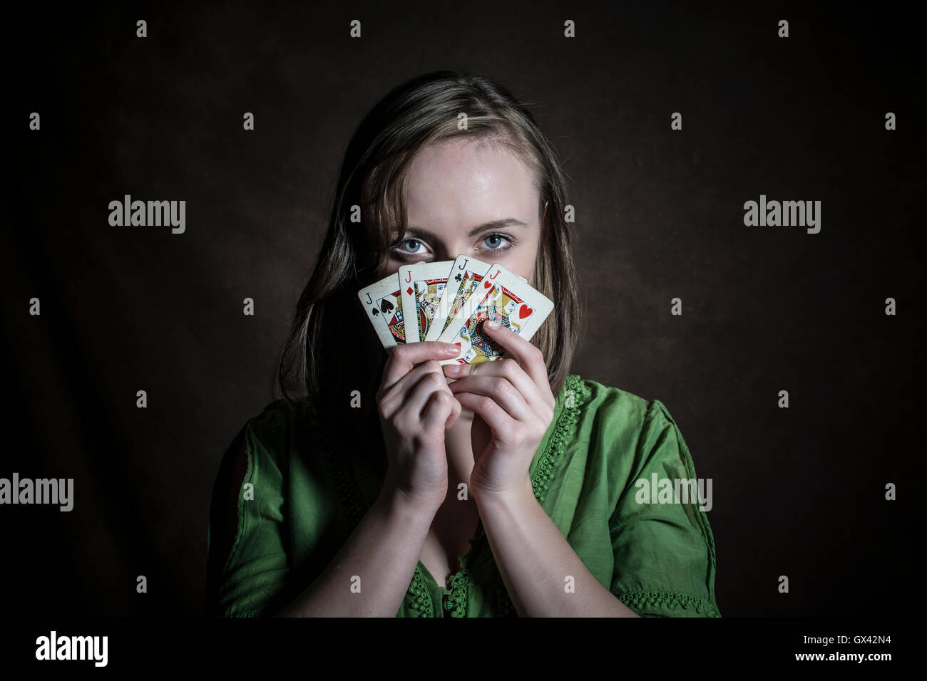 Woman hiding face with playing cards Stock Photo - Alamy