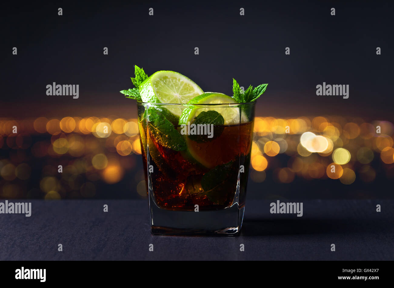 Cola with lime , ice and peppermint on a background of night city Stock ...