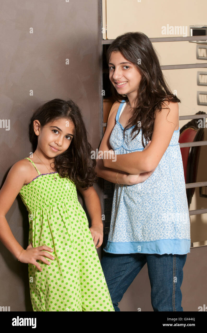 Two sisters standing indoors Stock Photo - Alamy