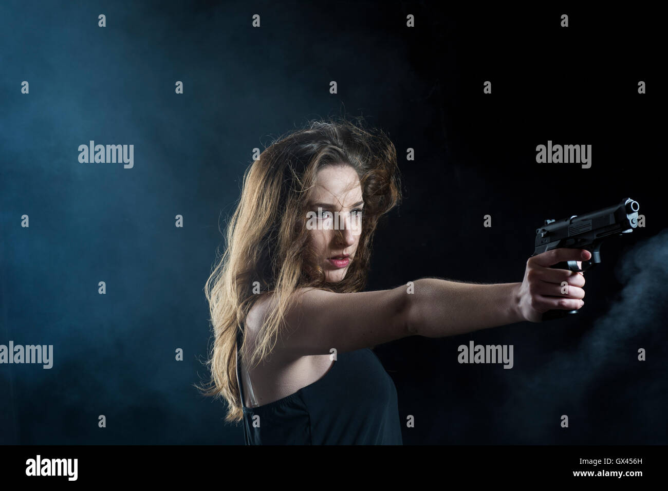 Woman aiming a gun Stock Photo - Alamy