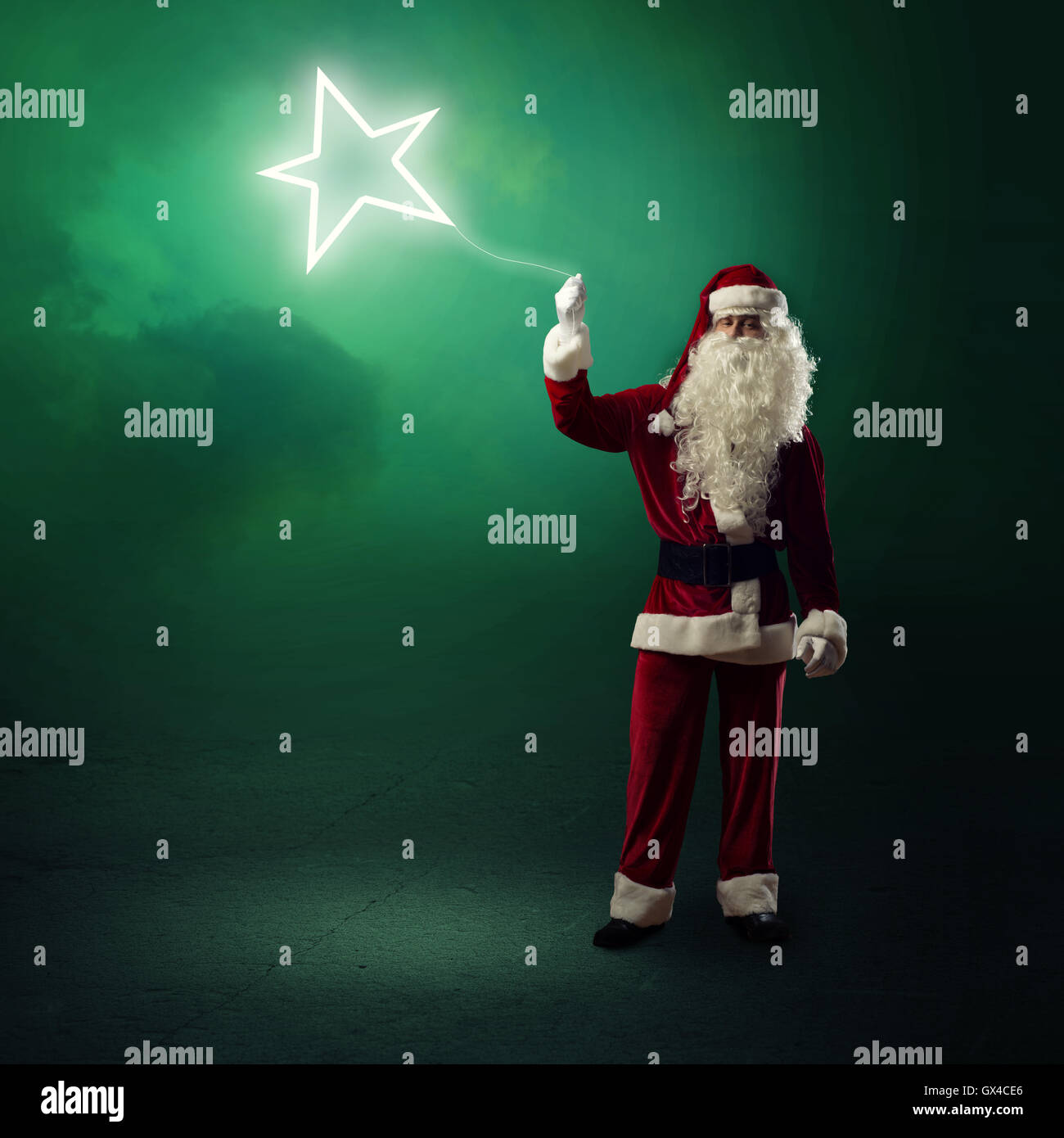 Santa Claus is holding a shining star Stock Photo - Alamy
