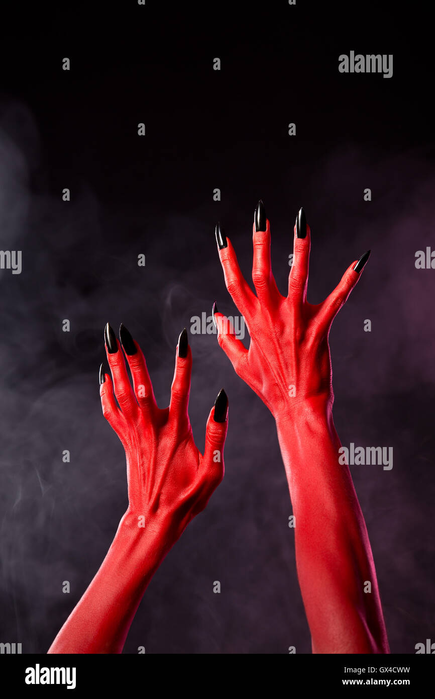 Red devil hands with black sharp nails, extreme body-art Stock Photo ...