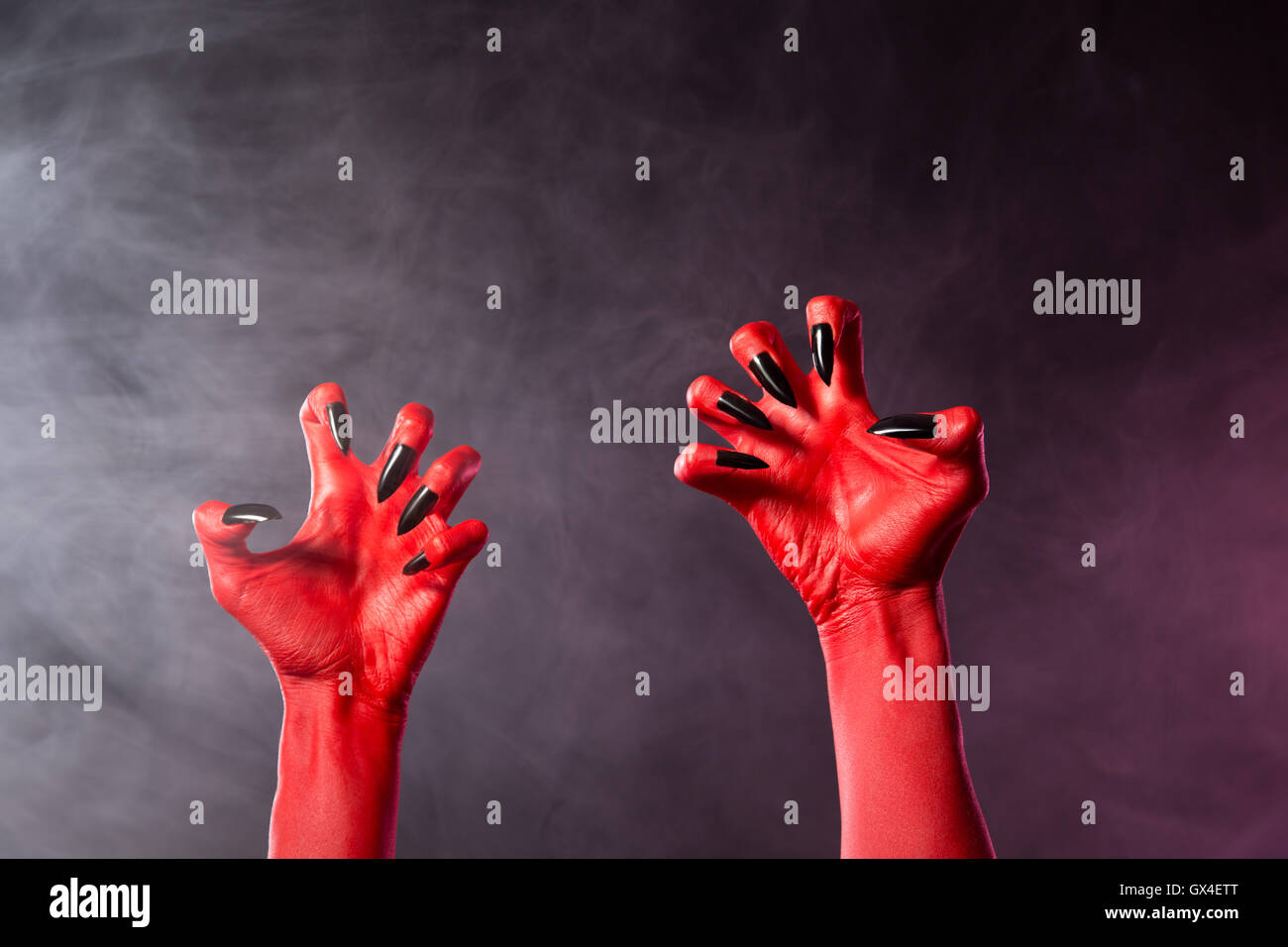 Scary red devil hands black hi-res stock photography and images - Alamy