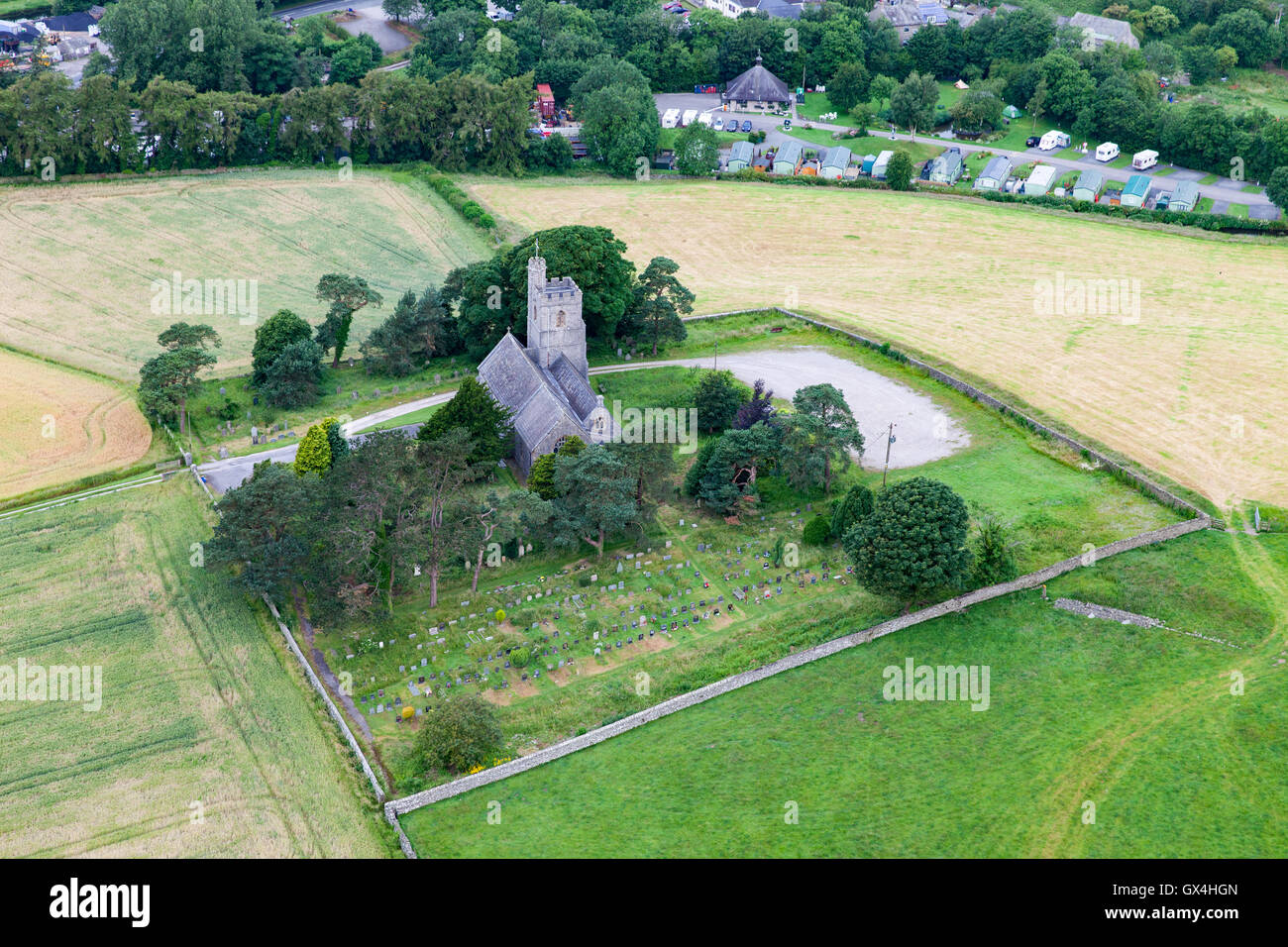 Aerial view of a historic church and graveyard surrounded by fields and ...