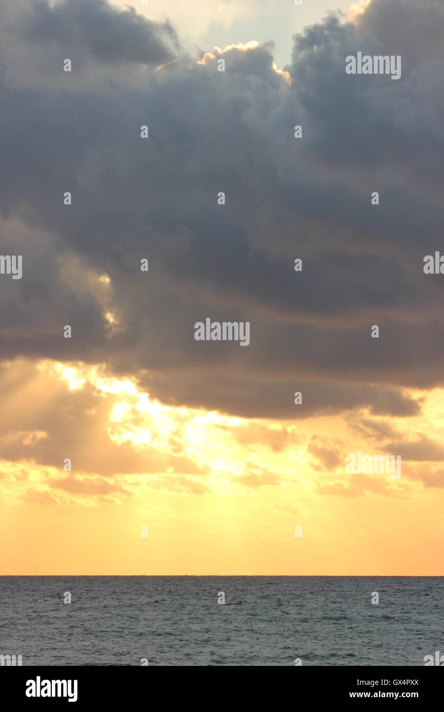 a beautifully moody sky with the sun behind the clouds, at sunset, with ...