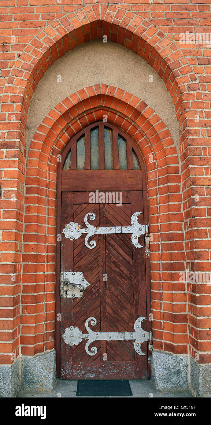 Wooden door bound in metal and set in brick in church at Dubeninki ...