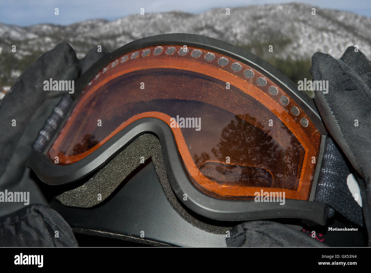 Snowboard goggles reflecting mountains and trees Stock Photo - Alamy