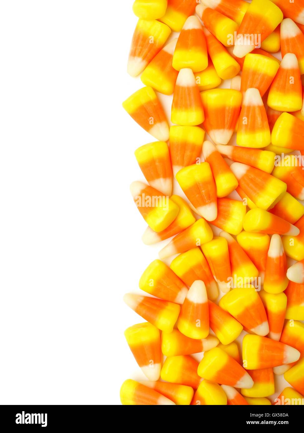 Halloween candy corn vertical border over white Stock Photo - Alamy