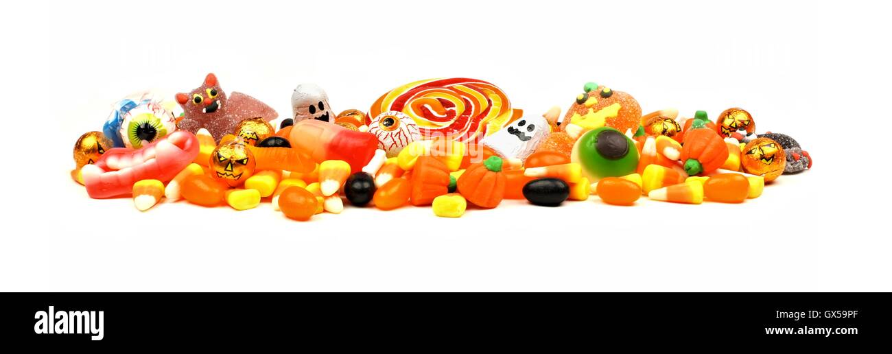 Long pile of colorful Halloween candy and sweets over a white ...