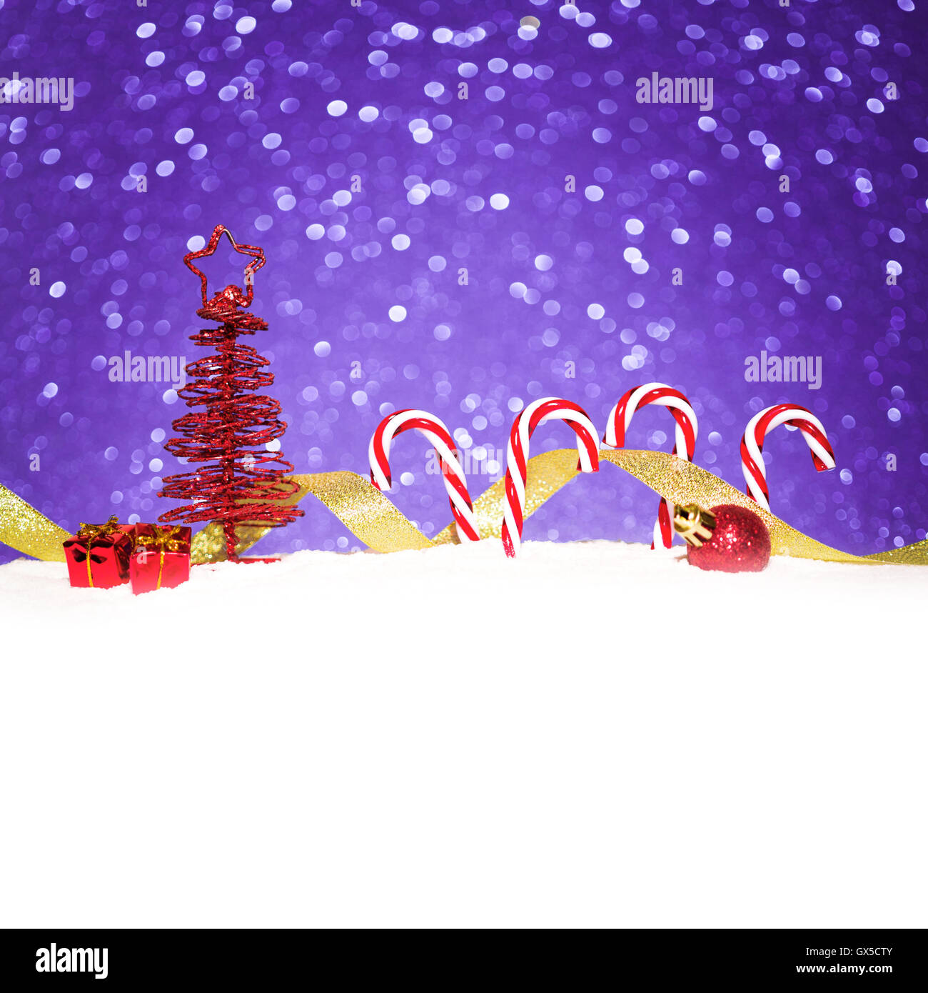 christmas tree and candy in snow on blue glitter background Stock Photo ...