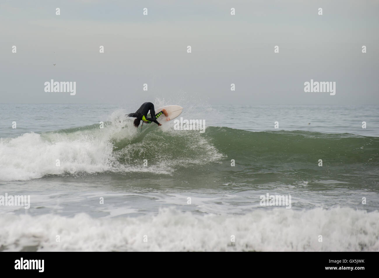 Surfer balancing on lip of waves while riding left Stock Photo - Alamy