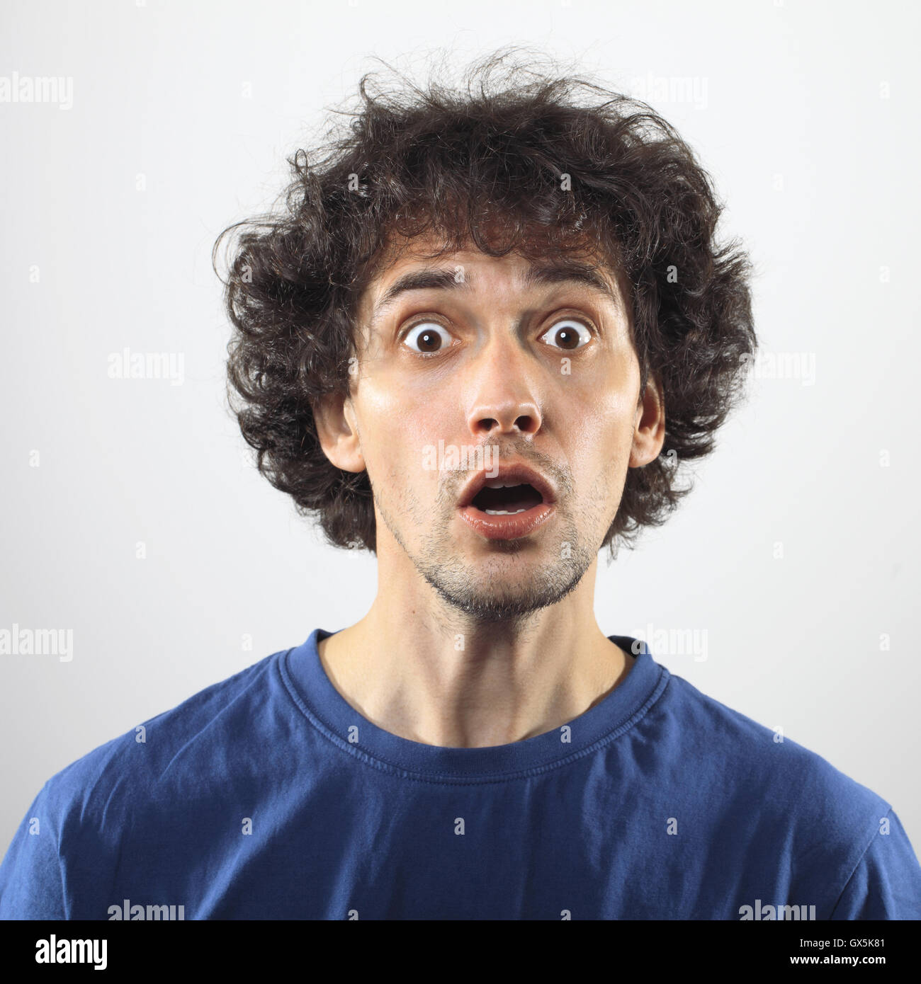 Surprised handsome young man in blue shirt Stock Photo - Alamy