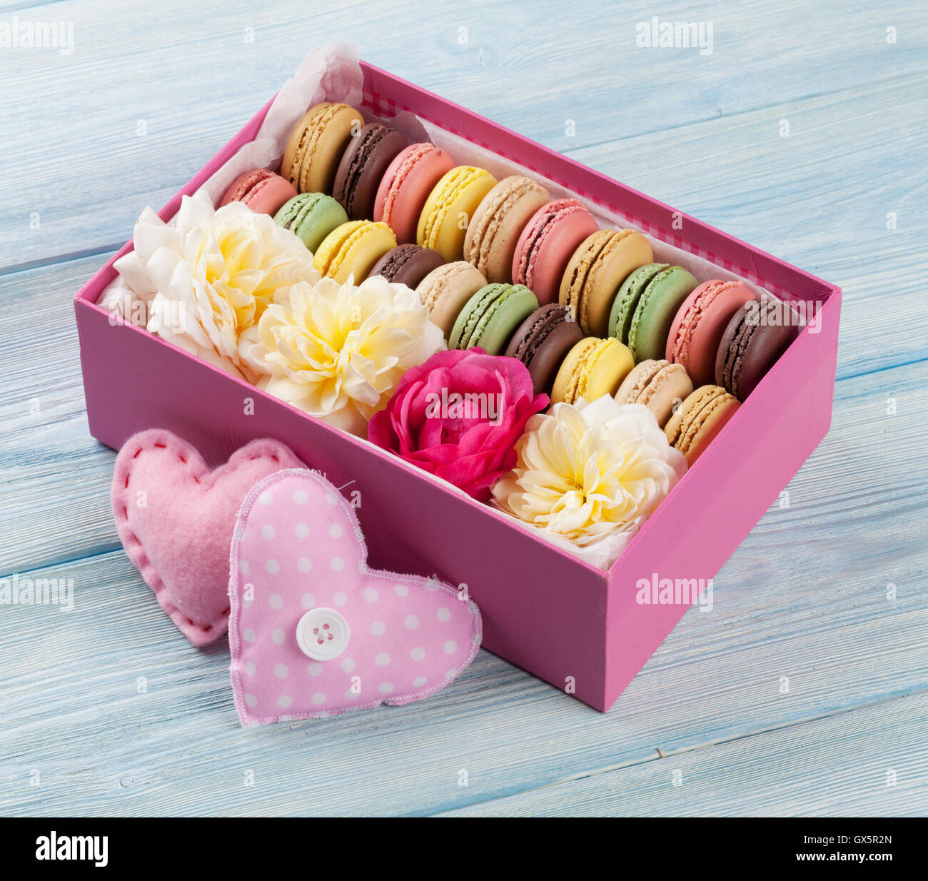 Colorful macaroons on wooden table. Sweet macarons in gift box and ...