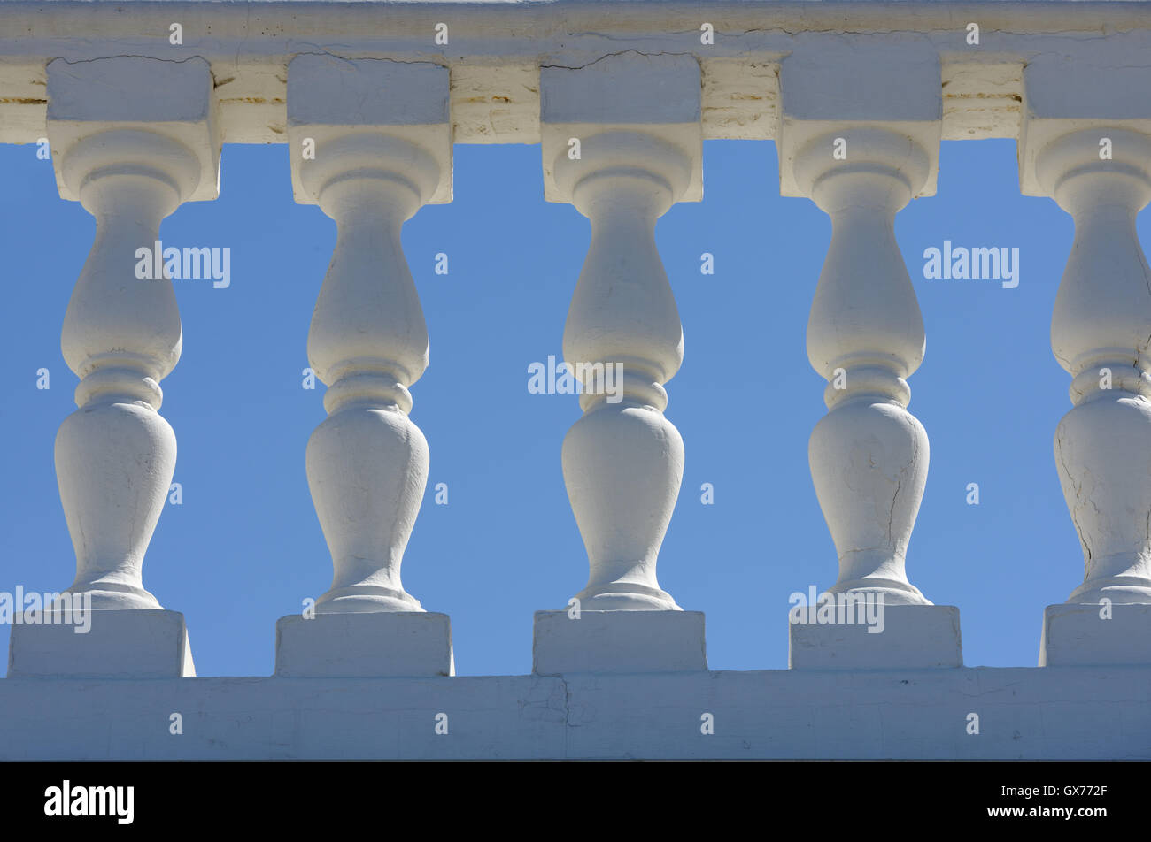 Old concrete balustrade painted white on blue sky background Stock ...