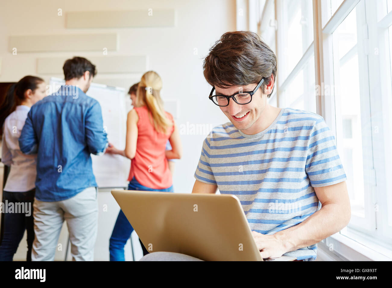 Student with laptop in a meeting as a programmer Stock Photo - Alamy