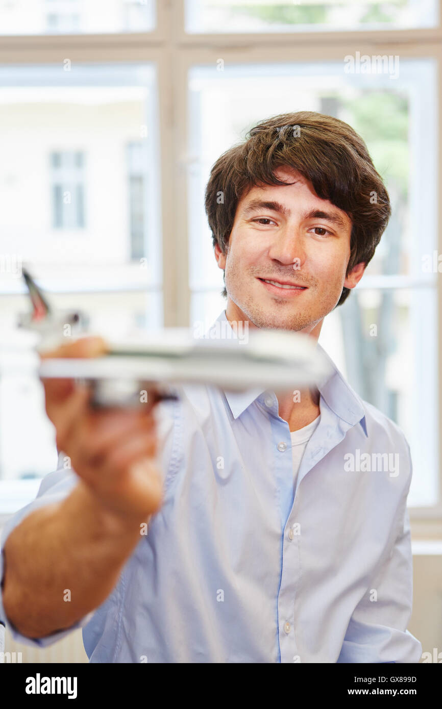 Designer with an airplane model in the office Stock Photo - Alamy