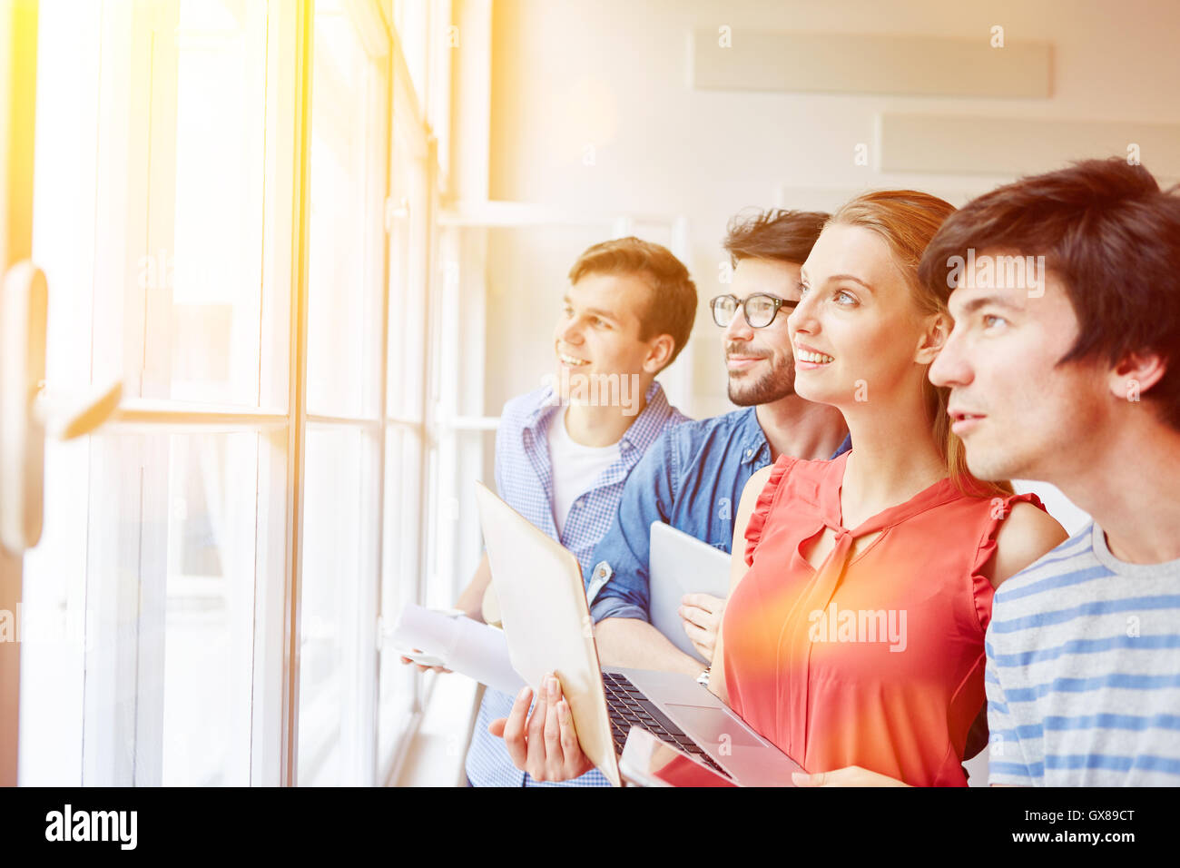 Start-up business team looking through window together Stock Photo - Alamy