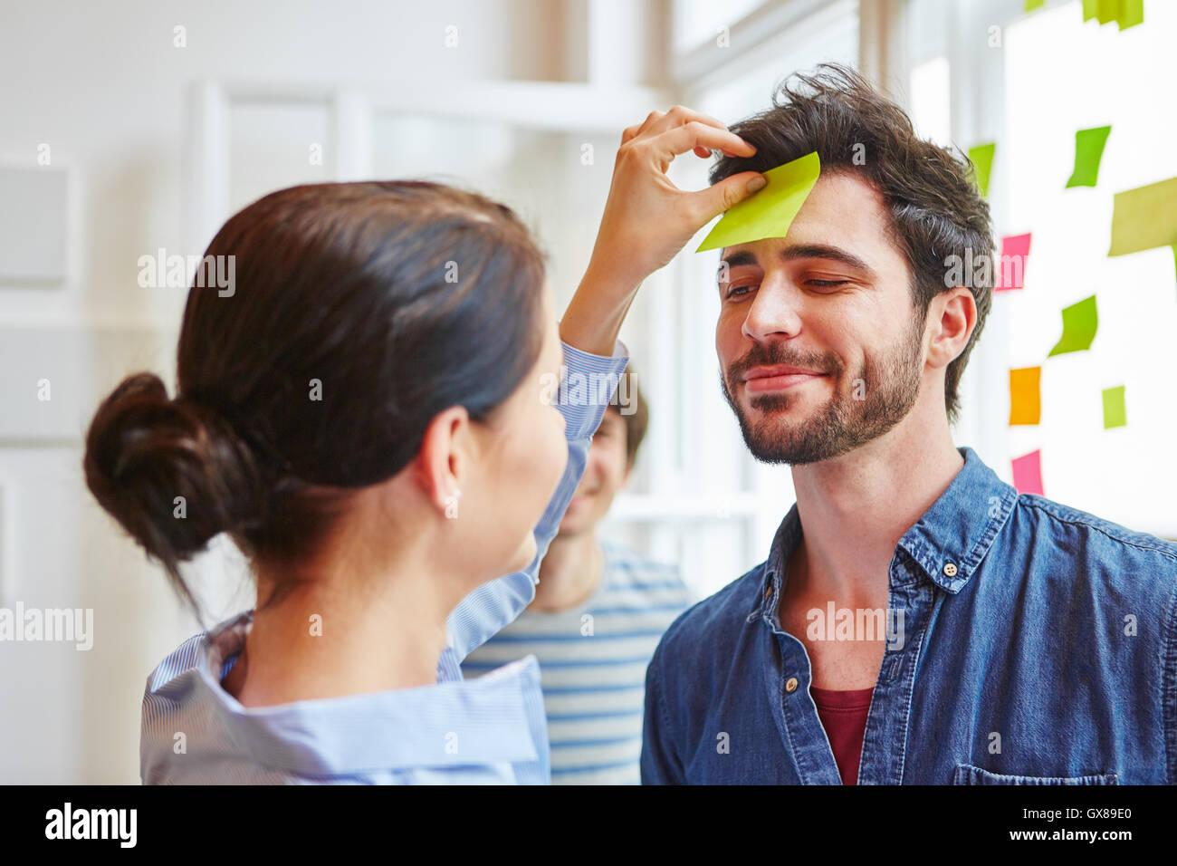 Man and woman playing with sticky notes in team building workshop Stock ...