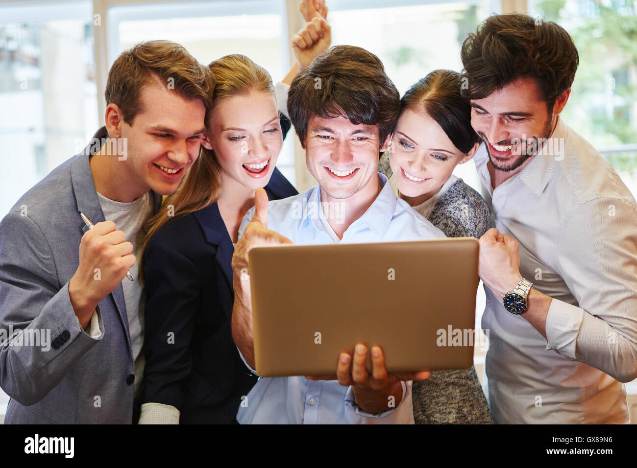 Start-up team with laptop celebrating their success Stock Photo - Alamy