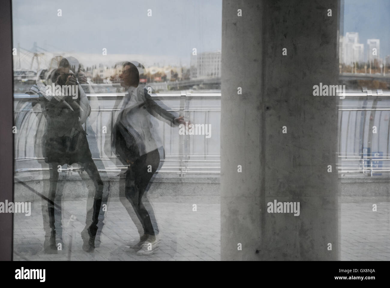 Two girls on the background of the city. Double reflection in the ...