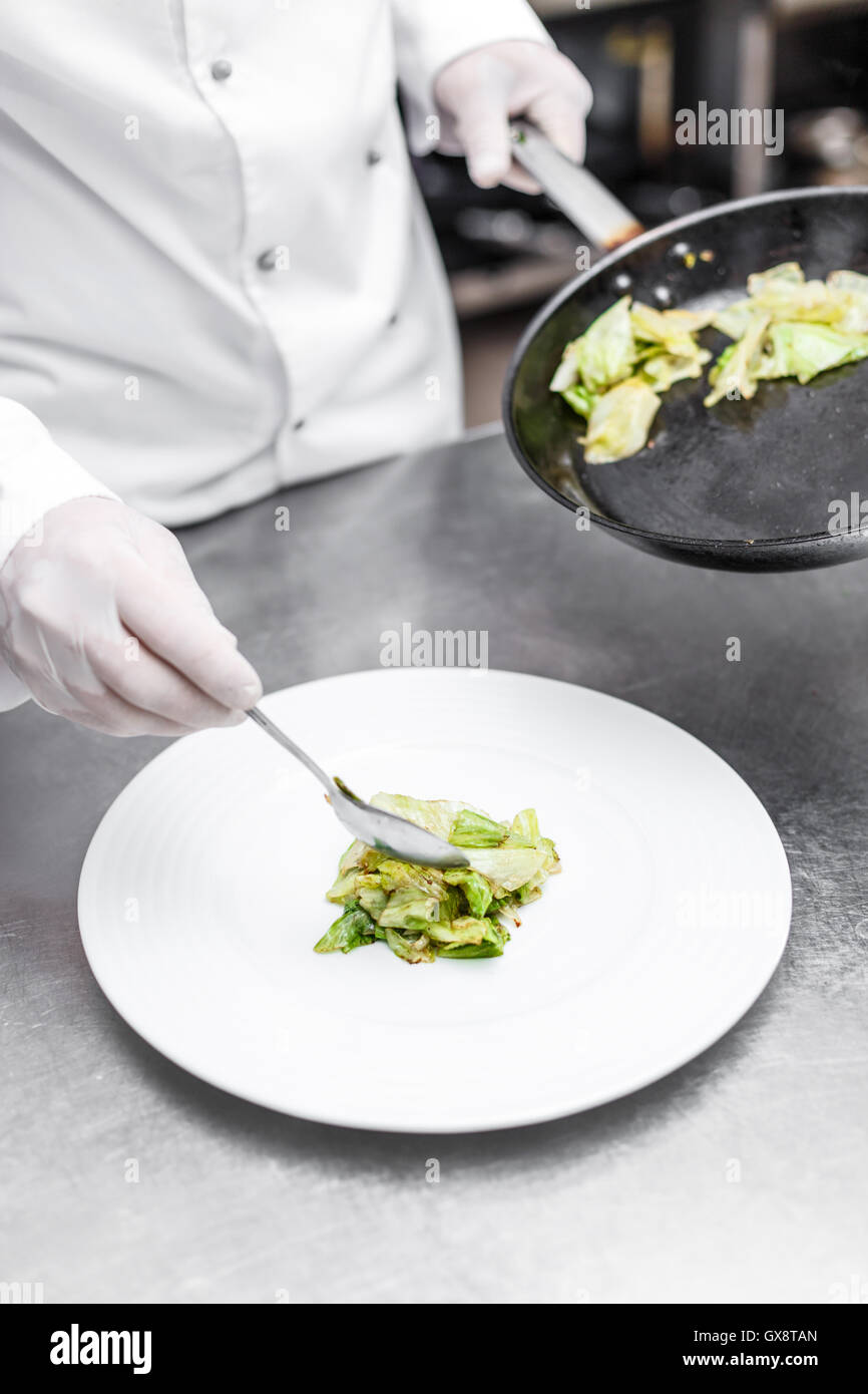 Chef add iceberg lettuce on plate Stock Photo - Alamy