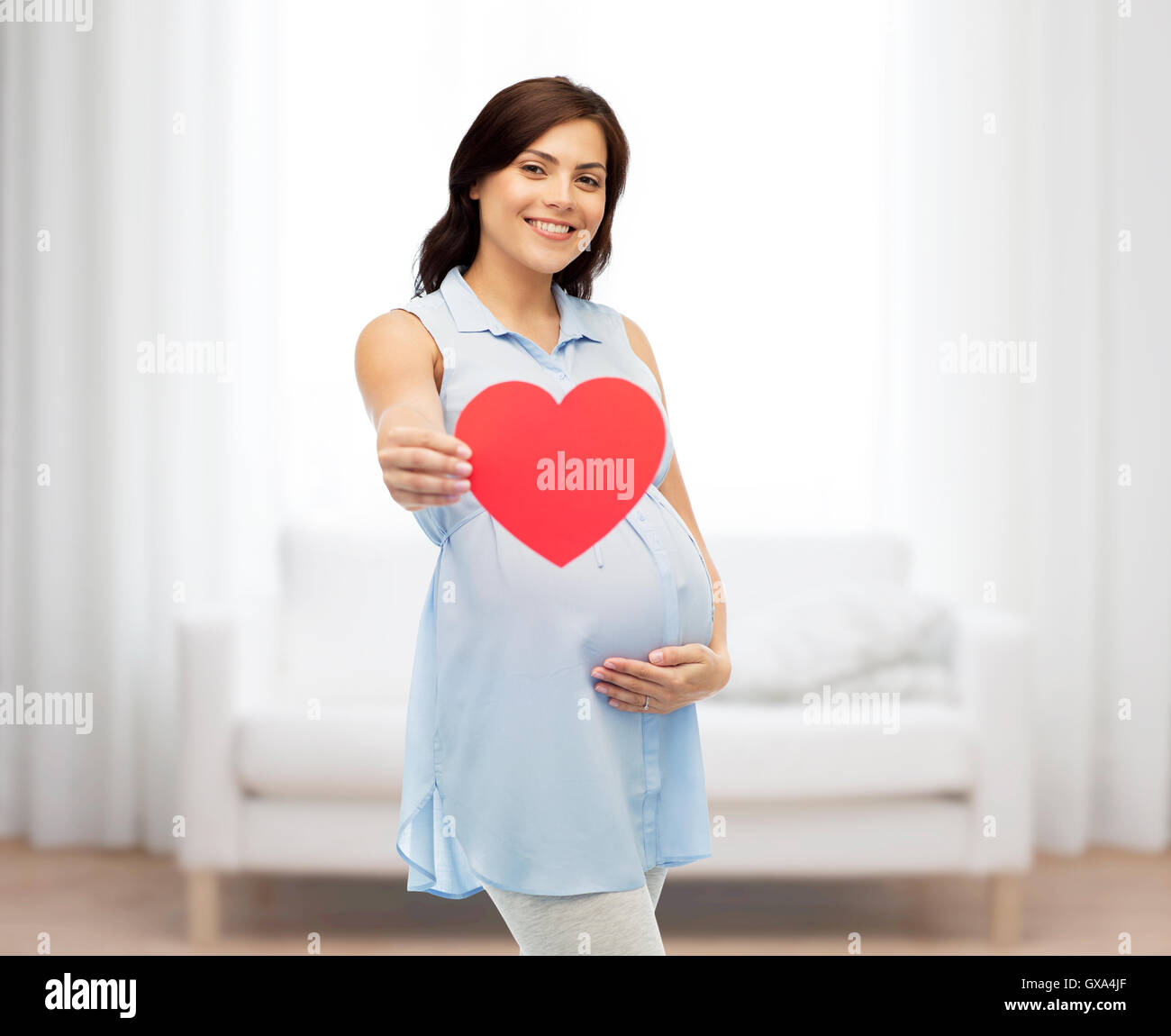 happy pregnant woman with red heart touching belly Stock Photo - Alamy