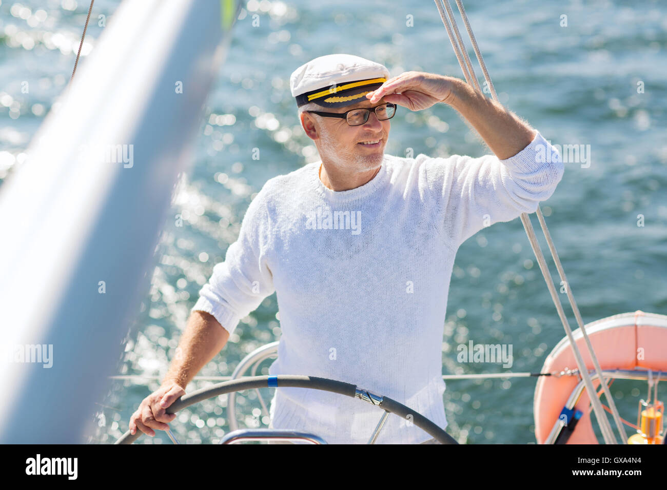 senior man at helm on boat or yacht sailing in sea Stock Photo - Alamy