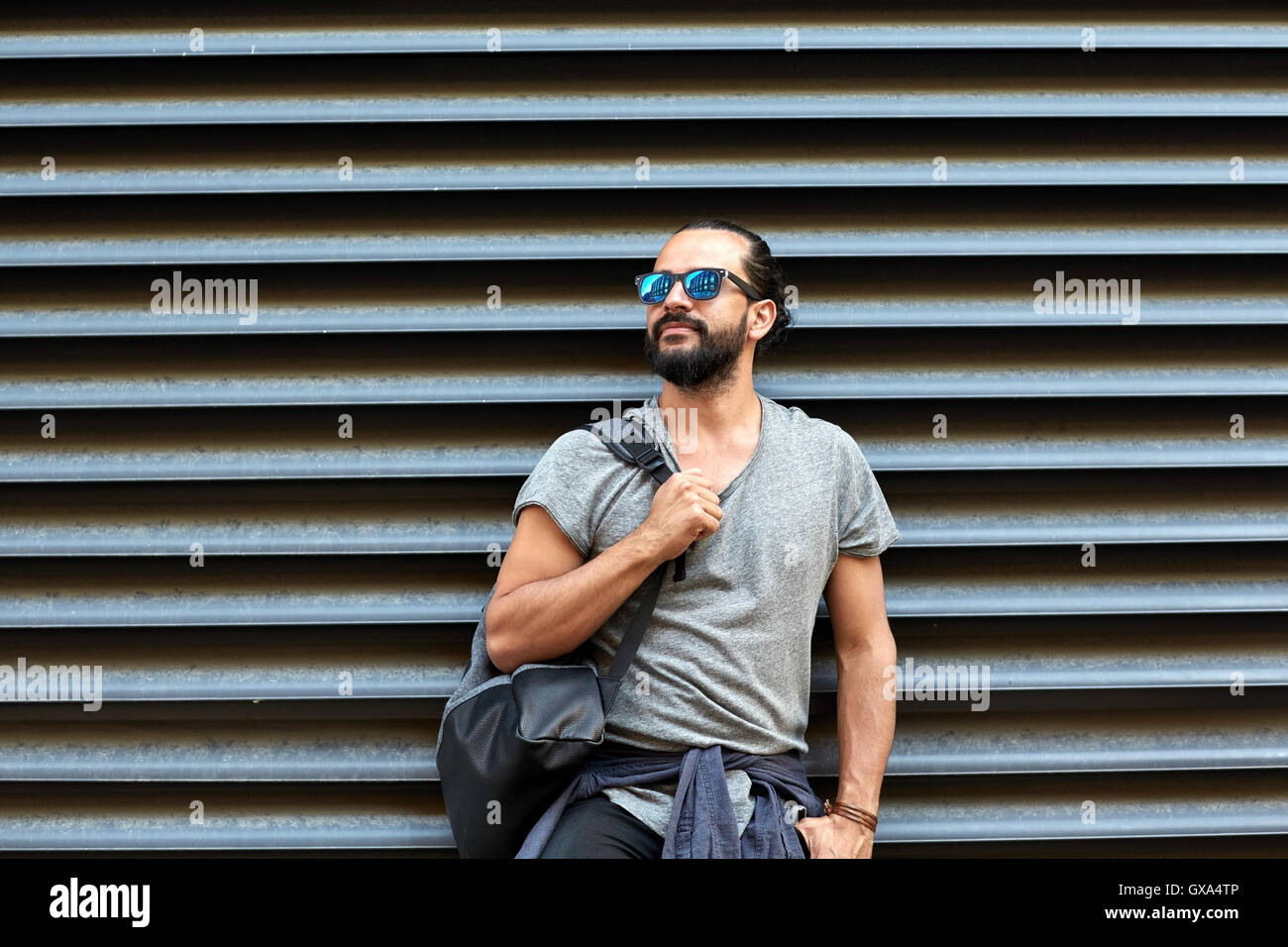 man with backpack standing at city street wall Stock Photo - Alamy
