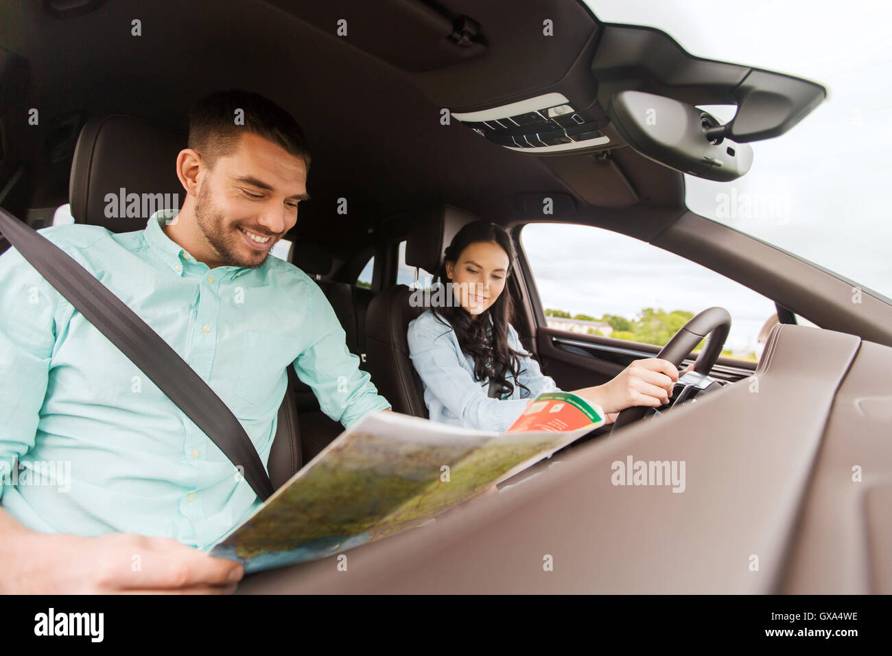 happy man and woman with road map driving in car Stock Photo - Alamy