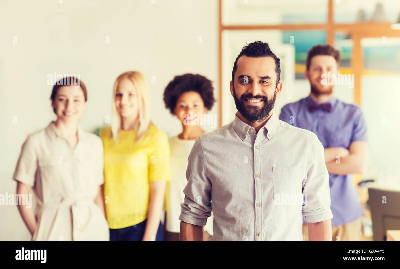 happy young man over creative team in office Stock Photo - Alamy