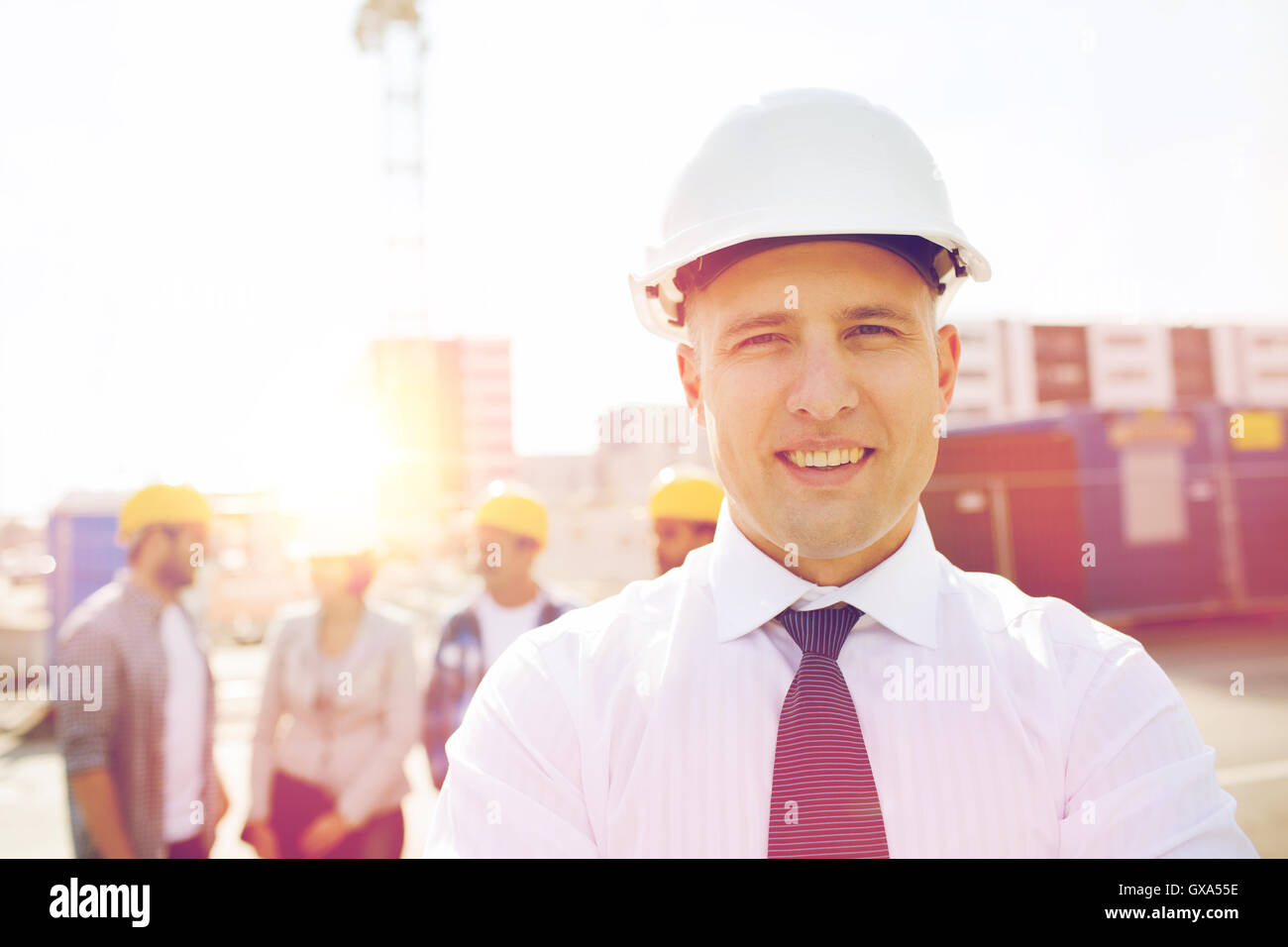 group of smiling builders in hardhats outdoors Stock Photo - Alamy