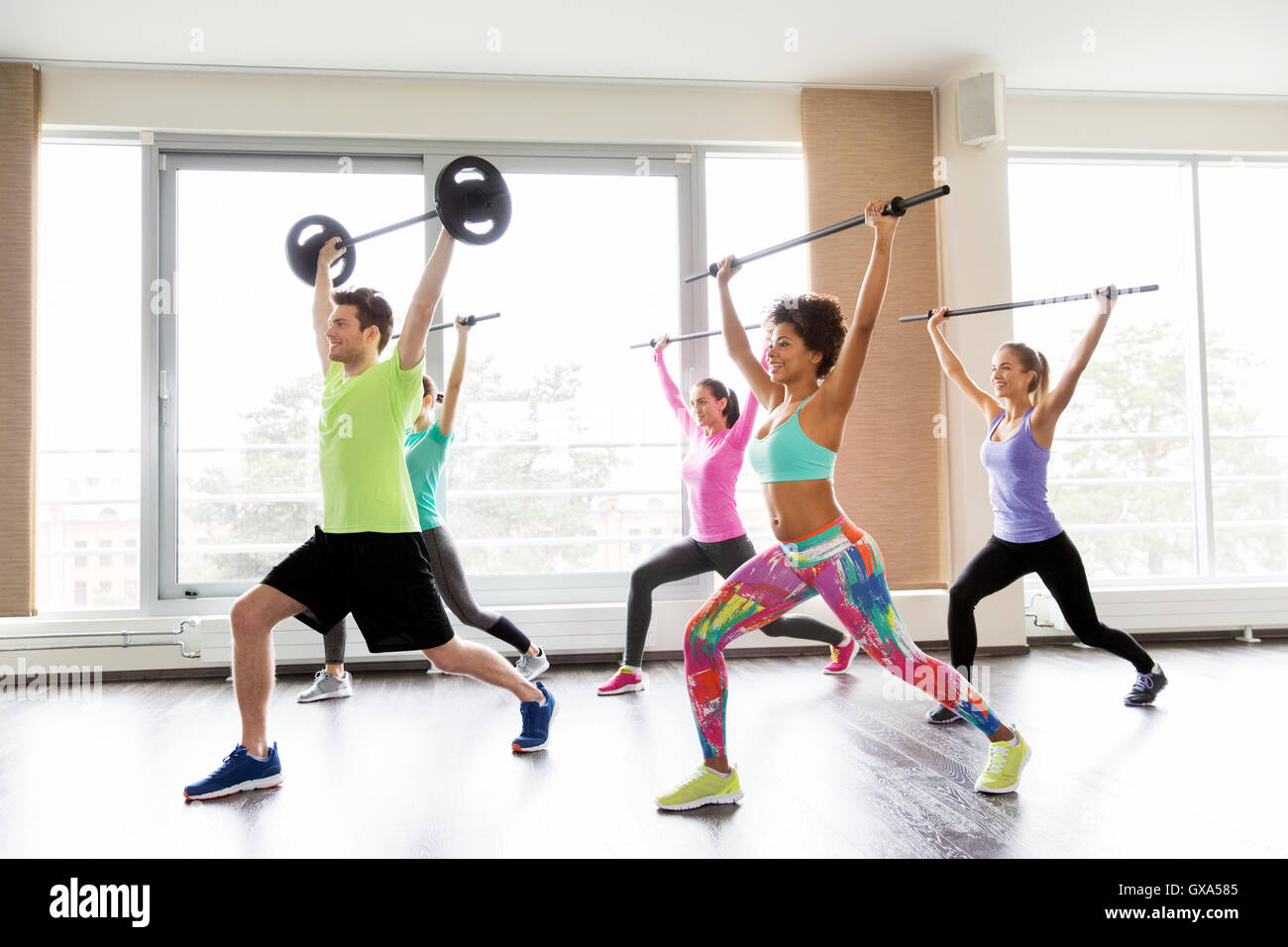 happy people exercising with barbell bars in gym Stock Photo - Alamy