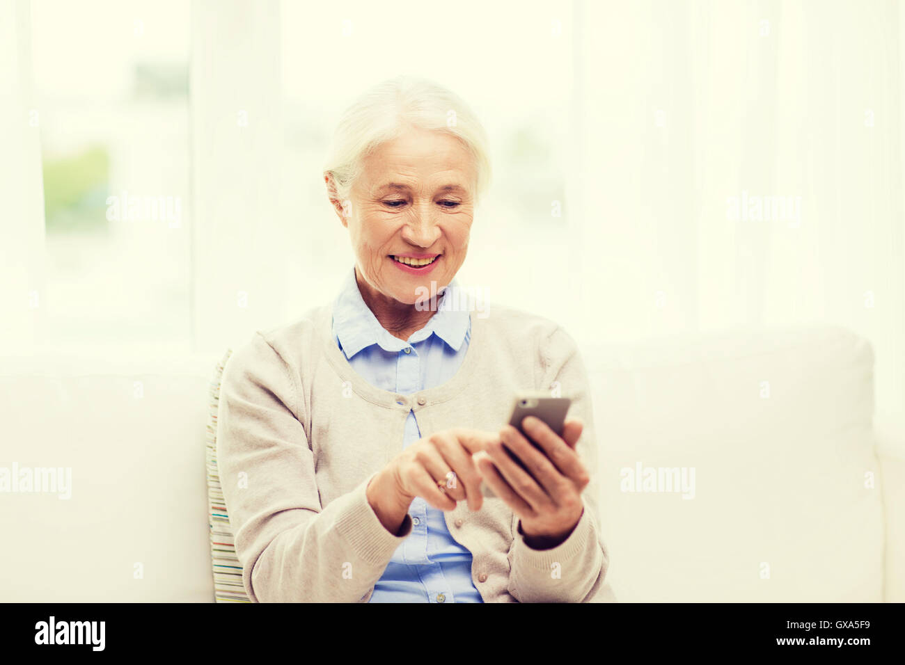 senior woman with smartphone texting at home Stock Photo - Alamy