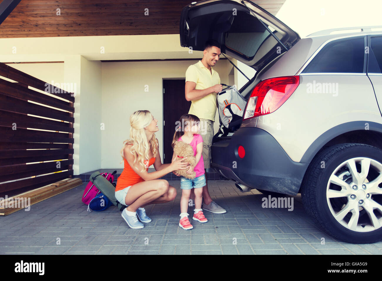 happy family packing things to car at home parking Stock Photo - Alamy