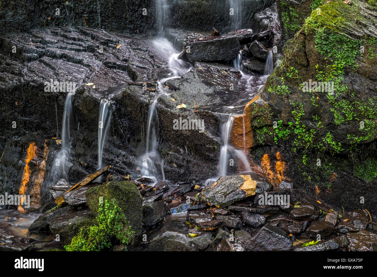 A multi fall waterfall showing copper markings on the rocks and ...