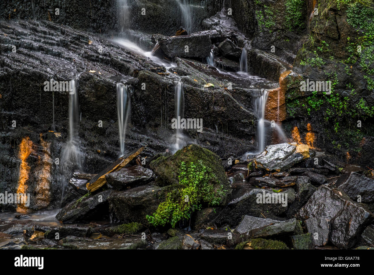 A multi fall waterfall showing copper markings on the rocks and ...