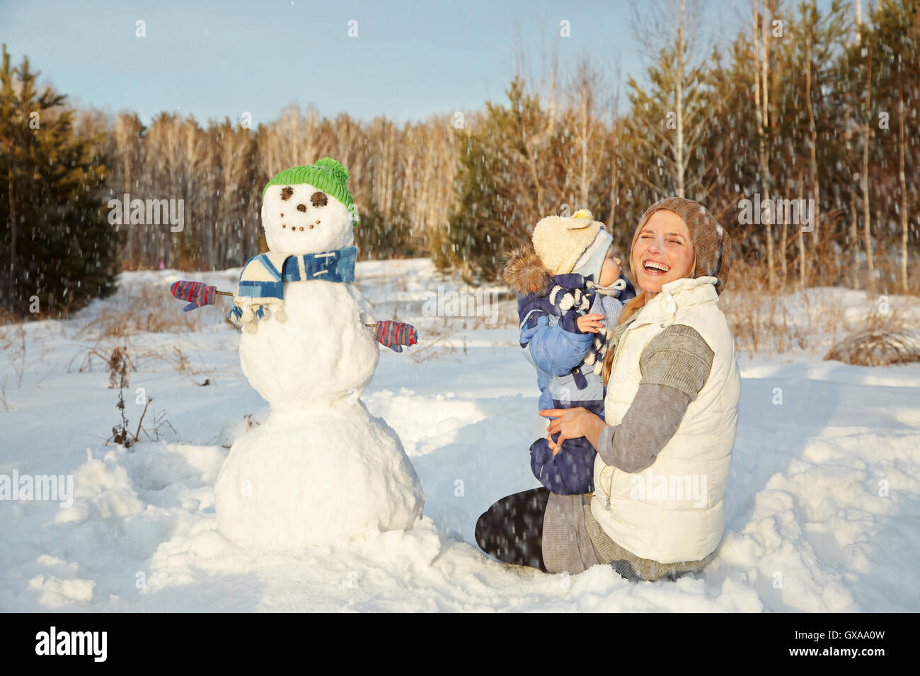 mother and baby with snowman Stock Photo - Alamy