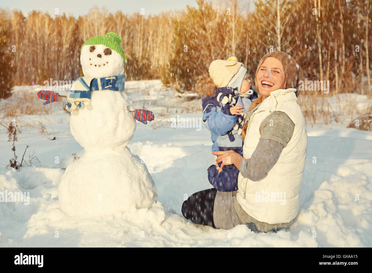 mother and baby with snowman Stock Photo - Alamy