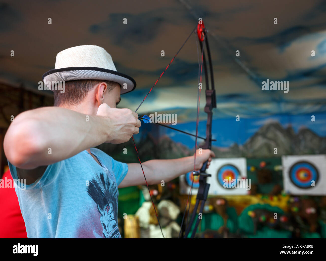 Young man shooting a bow at an amusement park Stock Photo - Alamy