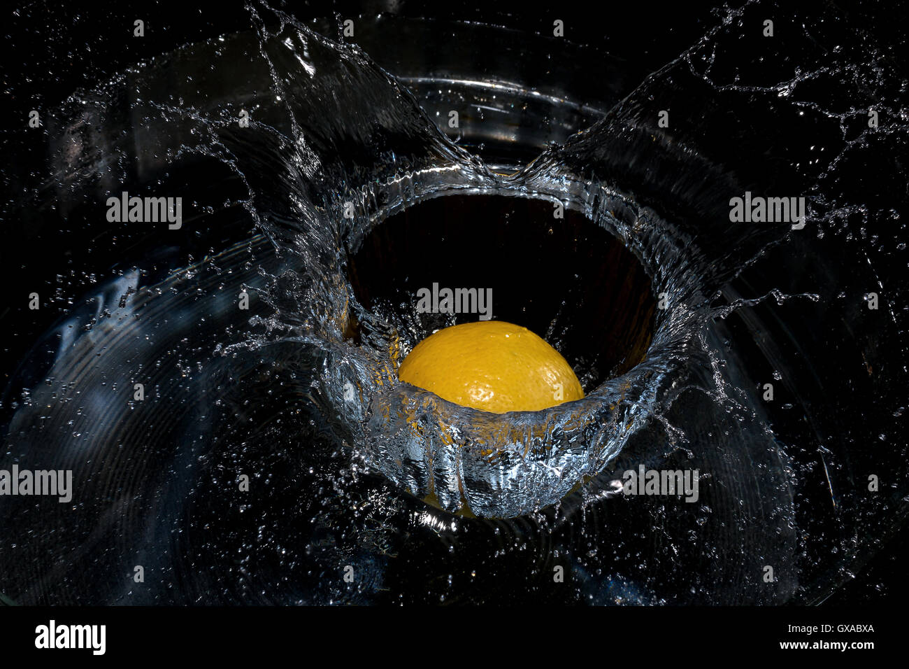 Lemon fallen into the crystal clear water and lifted up the big ...