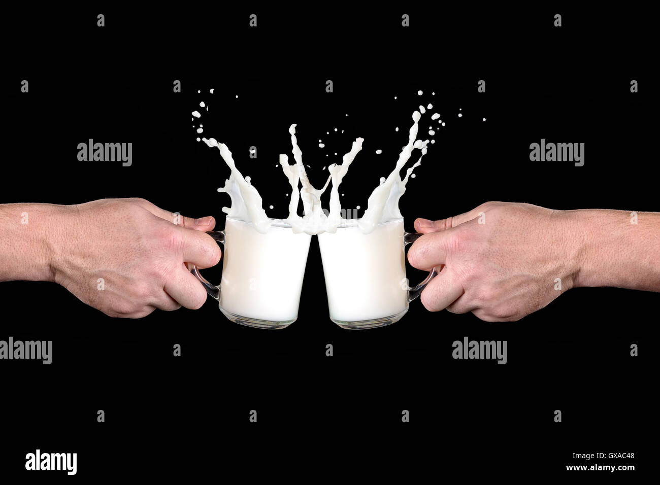 two cups with milk strike against each other, flying splash of milk ...