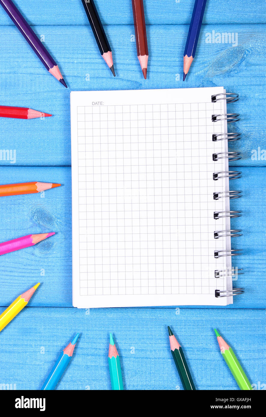 Colorful crayons and notepad for notes on blue boards, school supplies ...