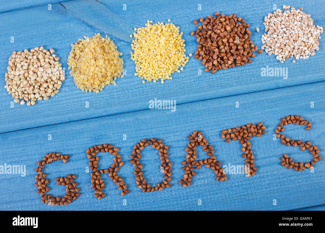 Inscription groats and heap of various groats on blue boards, concept ...