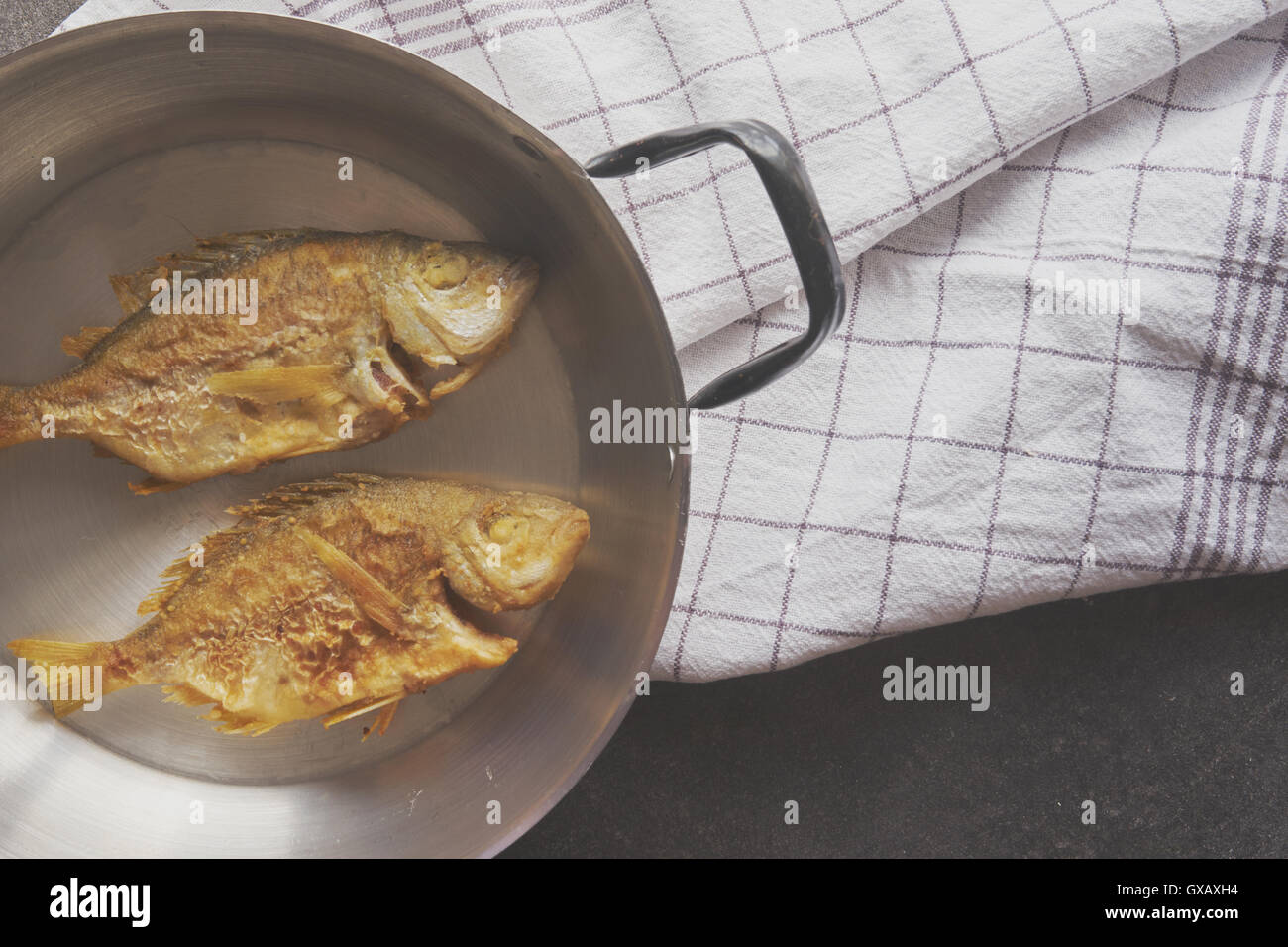 Fried fish in an old pan on the table, top view Stock Photo - Alamy