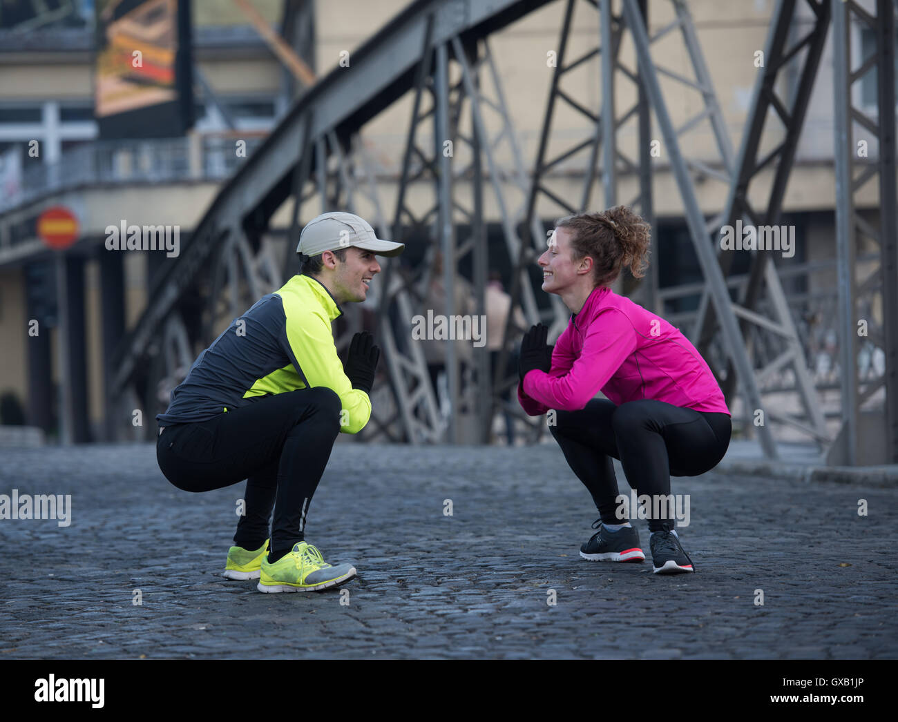jogging couple warming up and stretching before morning running in the ...