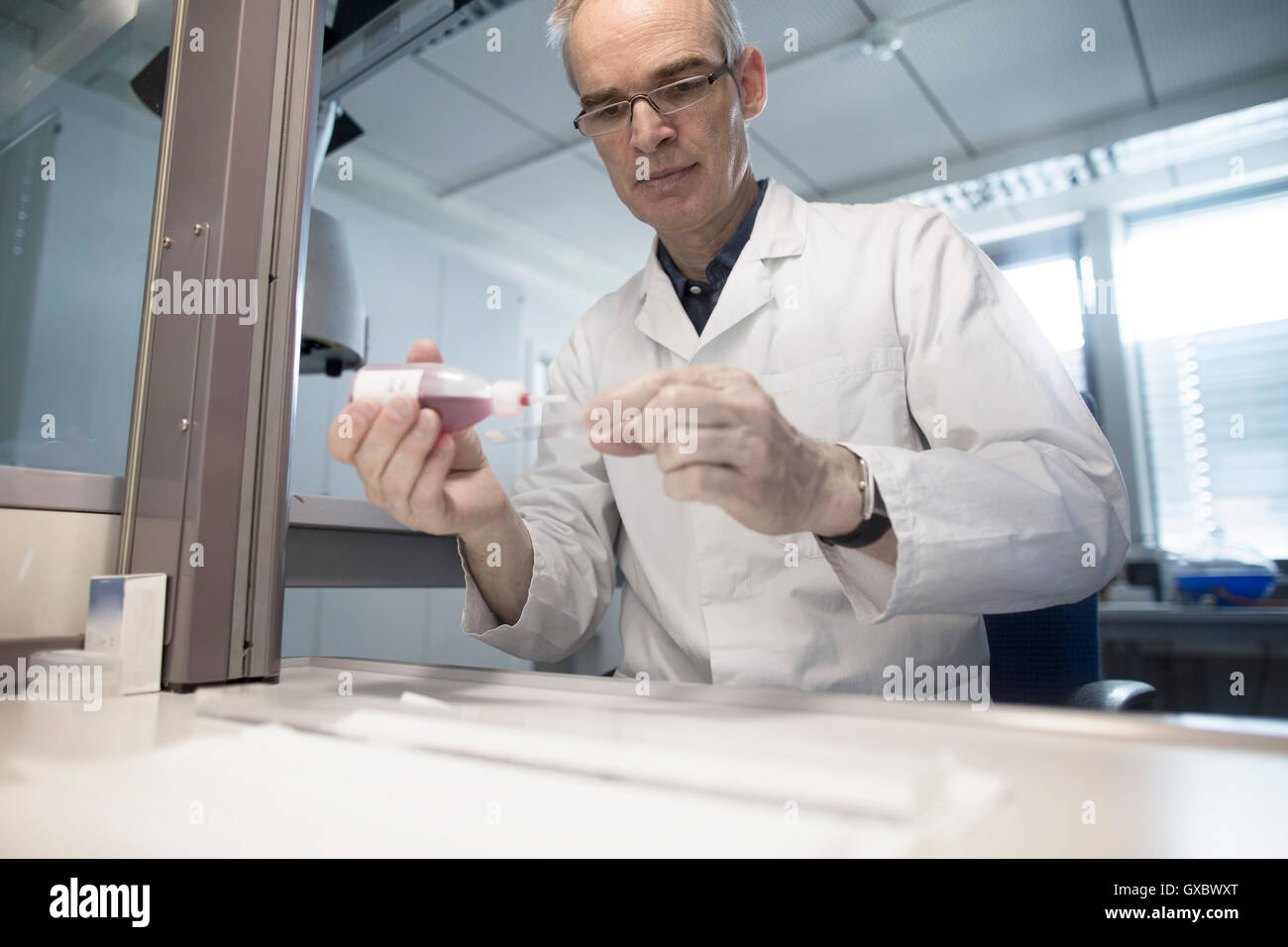 Male meteorologist preparing microscope slide in weather station ...