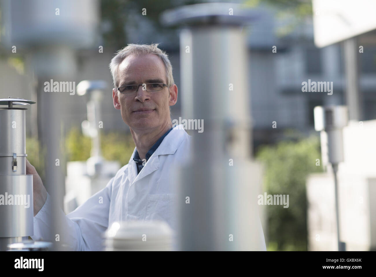 Portrait of male meteorologist amongst outdoor weather station ...