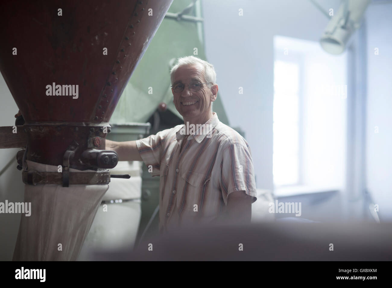 Portrait of male miller monitoring milling machine at wheat mill Stock ...